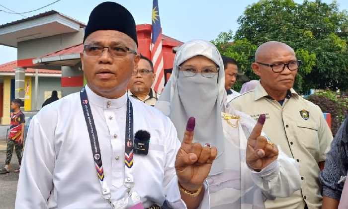 Cikgu Kasim, isteri mengundi di SMK Felda Chemomoi